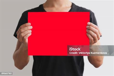 남자가 검은 T 셔츠 레드 빈 A4 용지를 가로로 들고 있다 전단지 프리젠테이션입니다 팜플렛에는 손을 잡으십시오 남자 쇼 명확한 오프셋된 종이입니다 시트 서식 파일입니다