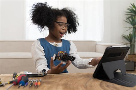 집에서 프로젝트 장난감 로봇 기술을 배우고 구축하는 여학생 교실에서 아프리카 계 미국인 어린이 소녀 훈련 및 제어 장난감 로봇