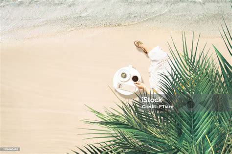 모래 해변의 바다 해안선 근처 야자수 아래 테이블에 앉아 케이크와 뜨거운 커피를 마시는 여자 여름 방학 야외 카페 공중 보기 세이셸에 대한 스톡 사진 및 기타 이미지