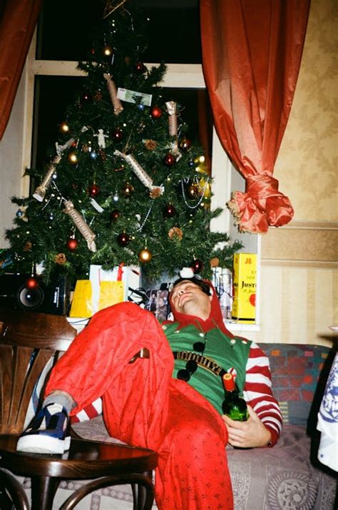 그린 크리스마스 트리 옆에 누워있는 남자 · 무료 스톡 사진