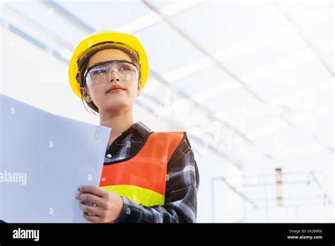 Asian Engineer Architect Worker Woman Holding Blueprint Infrastructure Progress At Construction