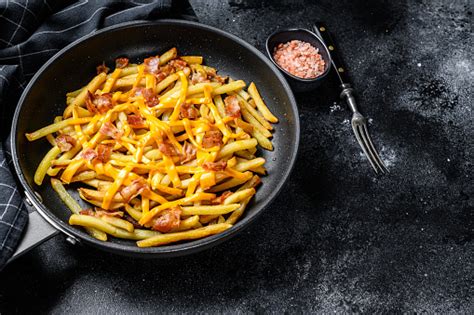 팬에 체다 치즈와 베이컨을 곁들인 황금 감자 튀김 검은 색 배경 맨 위 보기입니다 복사 공간 감자 요리에 대한 스톡 사진 및 기타 이미지 Istock