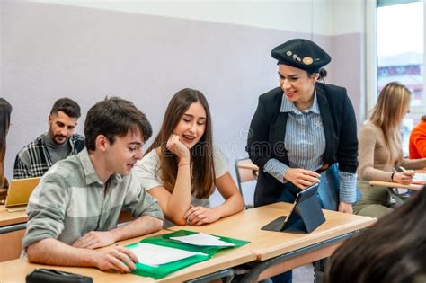 Teacher Helping University Students Studying Together In Classroom Stock Image Image Of