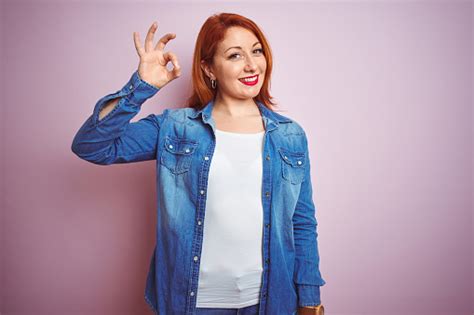 Youg 아름 다운 빨간 머리 여자 데님 셔츠를 입고 고립 된 분홍색 배경 웃고 긍정적 인 하 고 확인 기호 손과 손가락 성공적인 식입니다 T 셔츠에 대한 스톡 사진 및