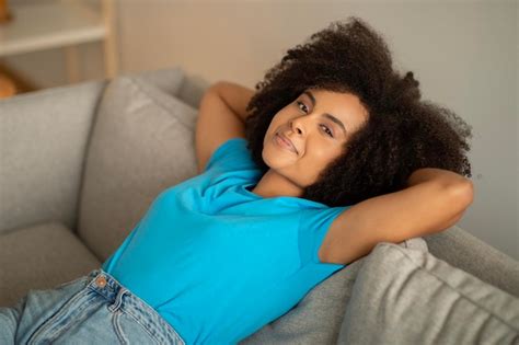 Premium Photo Cheerful Millennial Black Curly Lady Resting On Sofa