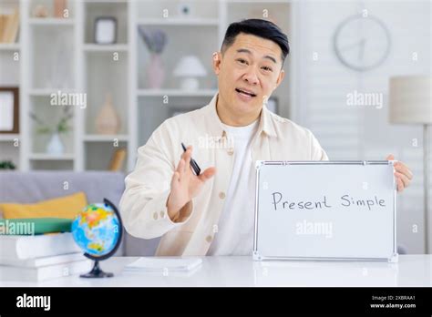 Smiling Teacher Conducting An Online Class Explaining The Present