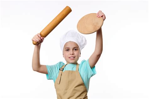 요리사 앞치마와 모자를 쓴 행복한 사춘기 전 아이 나무 보드와 롤링 핀을 들고 카메라를 본다 흰색 배경 개념에 대한 스톡 사진
