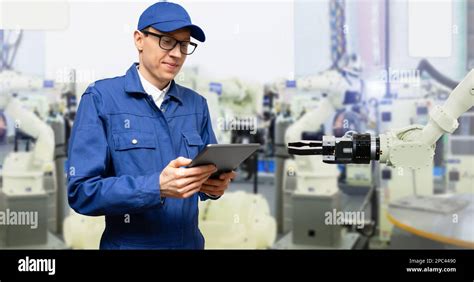Engineer Uses A Digital Tablet To Control Robots In A Smart Factory