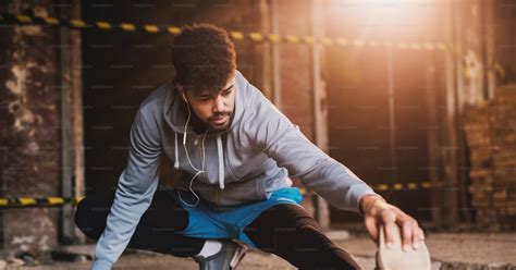 버려진 장소 안에서 다리 스트레칭 운동을 하는 활동적인 아프리카계 미국인 젊은 매력적인 운동 남자의 초상화를 닫습니다 사진 Unsplash의 세르비아 이미지