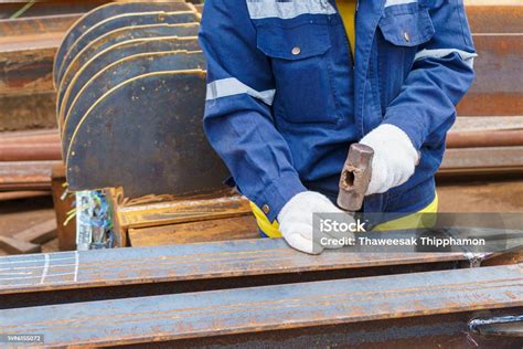 스탬프 문자와 숫자 작업자는 망치를 사용하여 식별 공작물을 위해 강철 구조 빔에 강철 핸드 스탬프로 문자와 숫자를 스탬프합니다 강철에 대한 스톡 사진 및 기타 이미지