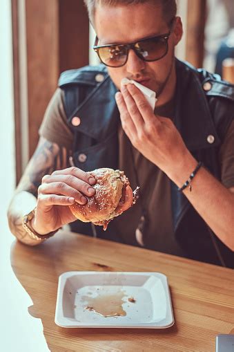 세련 된 머리와 수염 잘생긴 Hipster 햄버거를 먹고 길가 카페에서 식사 하기로 한 테이블에 앉는 다 T 셔츠에 대한 스톡 사진 및 기타 이미지 Istock