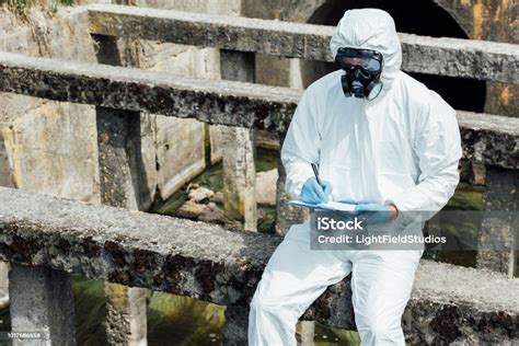 남성 과학자 보호 마스크 및 슈트 하 수도 가까이 앉아있는 동안 클립보드에 쓰기 Stem 주제에 대한 스톡 사진 및 기타 이미지 Stem 주제 과학 과학 실험