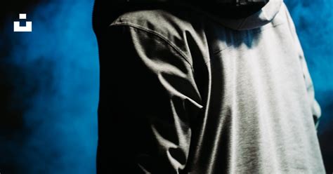 얼굴에 푸른 연기가 나는 회색 까마귀를 입은 남자 사진 Unsplash의 무료 의복 이미지