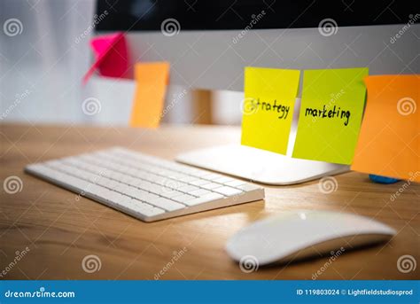 close up view of colorful sticky notes with marketing and strategy lettering on computer screen