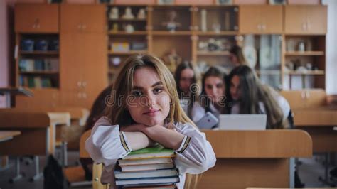 Une étudiante Pose Avec Des Manuels à Son Bureau Dans Sa Classe Photo