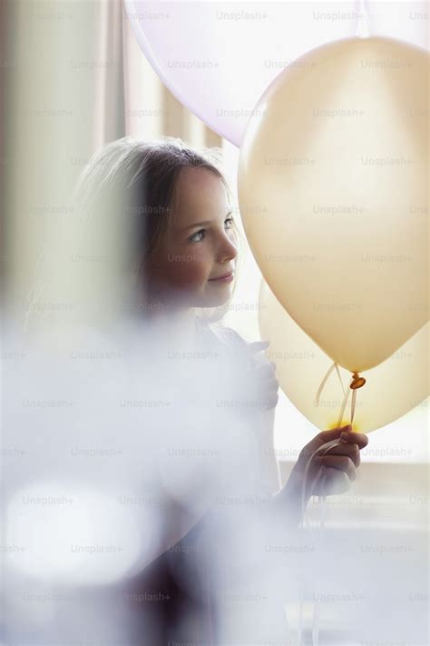 손에 풍선을 들고 있는 어린 소녀 사진 Unsplash의 한 사람 이미지