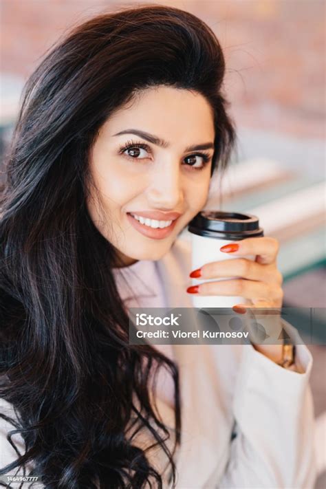 아름다움 젊음 라이프 스타일 및 휴식 개념 젊은 갈색 머리 여성 과 잘 모양의 얇은 눈썹 건강한 피부와 빨간 매니큐어 들고 테이크 아웃 커피 카메라 미소로 유쾌하게 찾고