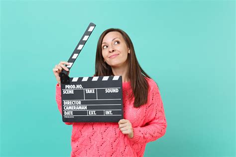 꿈꾸는 듯한 젊은 여자에서 찾고 만드는 Clapperboard 파란색 벽 배경 스튜디오 초상화에 고립 된 고전적인 흑인 영화를