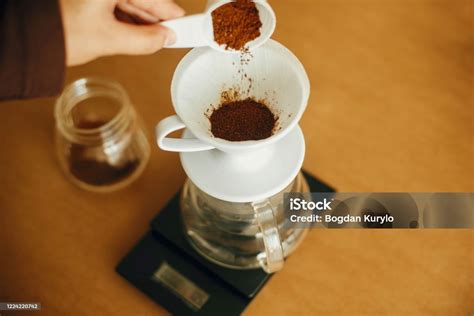 필터에 접지 커피를 붓는 손은 규모의 유리 주전자에 부어 대체 커피 양조 V60준비 갈색 배경에 갈기 커피와 숟가락을 들고 있는 사람 가루로 빻은에 대한 스톡 사진 및 기타