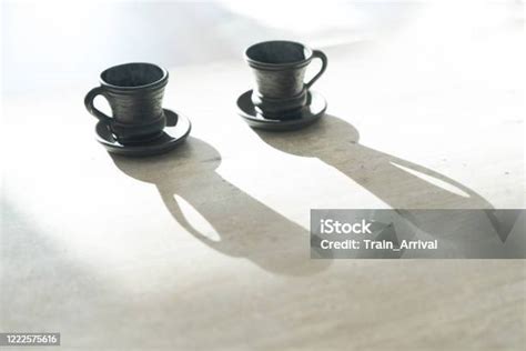 긴 컵 그림자를 그리는 밝은 백라이트가있는 테이블에 커피 점토 검은 컵 두 개 현대 부엌 개념의 커플을위한 커피 0명에 대한