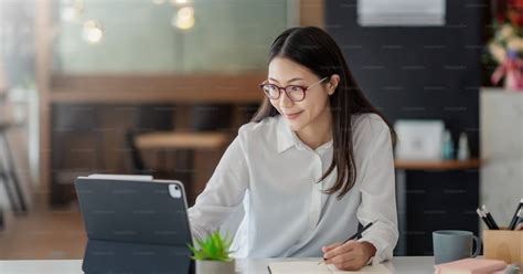 태블릿으로 작업하고 사무실에서 메모를 하는 젊은 아시아 여성 사진 Unsplash의 태국 이미지