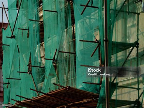 집의 외관의 수리 비계는 플라스틱 직물로 만든 파란색 투명 그물로 덮여 있습니다 콘크리트 벽돌과 물체의 조각이 있도록 정착민뿐만 아니라 보행자를 보호합니다 건물 외관에 대한