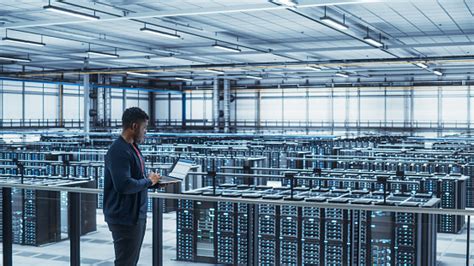 랩톱 컴퓨터를 사용하는 데이터 센터 엔지니어 사이버 보안을 위한 데이터 보호 네트워크와 함께 작업하는 블랙 남성 시스템 관리자가 있는 서버 팜 클라우드 컴퓨팅 전문가 시설