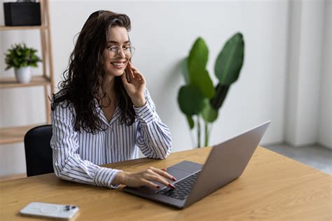 일을 위해 휴대 전화와 노트북을 사용하는 행복한 여자 재택근무를 하는 자신감 넘치는 여성 사업가 노트북에 대한 스톡 사진 및 기타 이미지 Istock