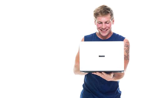 전체 길이 정면 보기 1 명 만 2029세 성인 잘생긴 사람 코카서스 남성 젊은 남성 서 탱크 탑 청바지 바지 캔버스 신발 웃고