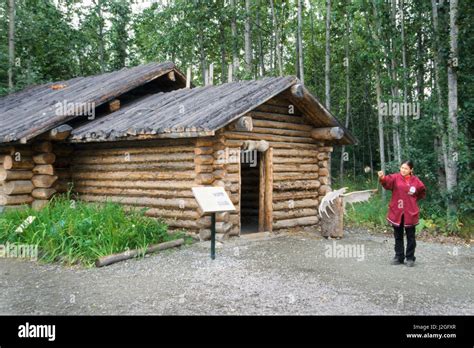 Native Interpreter Next To Athabaskan Log Dwelling Demonstrates A Traditional Yo Yo Made From