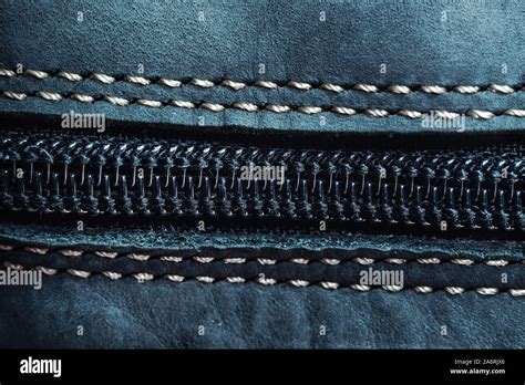 close up beautiful zipper on black leather texture background with stitching macro photography