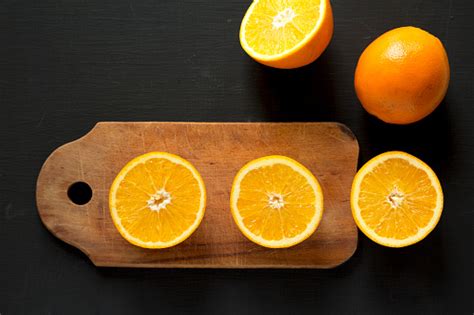 검은 표면에 소박한 보드에 반으로 자른 전체 오렌지 상단 보기 오버 헤드 위에서 평평한 평지 0명에 대한 스톡 사진 및 기타 이미지 Istock