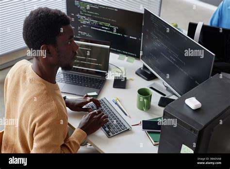 Serious African American Developer Working With Security Codes On Computer At His Workplace