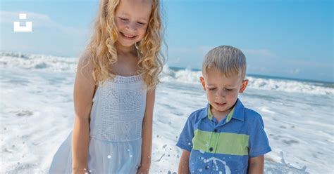 낮 동안 파란색과 녹색 폴로 셔츠를 입은 소년 옆에 서 있는 흰색 민소매 드레스를 입은 소녀 사진 Unsplash의 무료 톱세일 비치 이미지