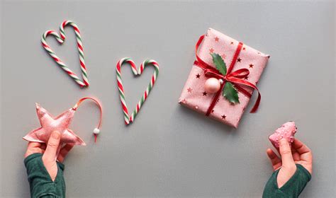 사탕 지팡이로 만든 하트 스타 장신구와 진저 브레드와 여성의 손 싸여 핑크 선물 상자와 축제 크리스마스 배경 회색 종이에 장식 플랫 누워 12월에 대한 스톡 사진 및 기타