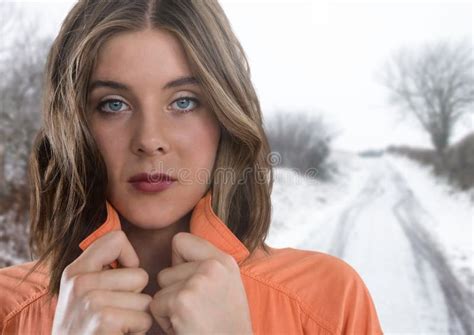 Woman Holding Her Jumper Tight Keeping Warm In Snow Countryside Stock