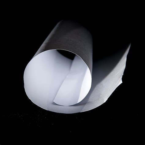 Premium Photo Close Up Of Rolled Paper Against Black Background