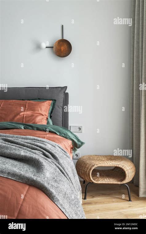 Bedroom Interior With Rust Color Linen And Cushions On A Bed Grey Blanket Rattan Bedside Table
