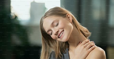 이빨 미소를 지닌 젊은 금발 여성은 목과 몸에 천연 수제 화장품을 바르고 아침에 그것을 즐기고 있다 사진 Unsplash의 초상 이미지