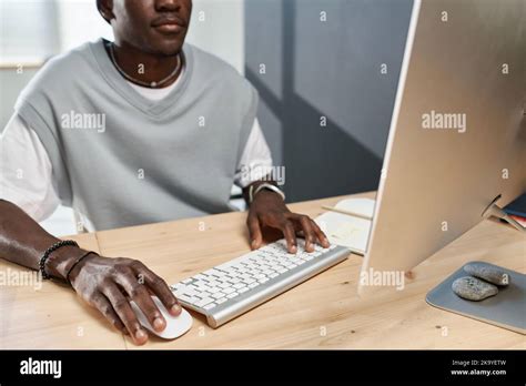 Close Up Of Young Black Man In T Shirt Clicking On Mouse And Pressing Button Of Computer