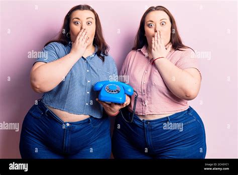 Young Plus Size Twins Holding Vintage Telephone Covering Mouth With