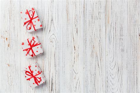 발렌타인 데이 또는 다른 휴일 수 제 종이에으로 현재 휴가 래퍼에 빨간 하트와 선물 상자 디자인을 위한 복사 공간 흰색 나무 테이블 상단 보기 빈 공간에 선물 상자를 제시