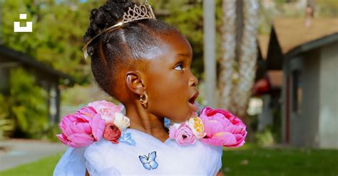 하얀 드레스를 입은 어린 소녀가 나무와 건물을 배경으로 잔디밭에 앉아 있다 사진 Unsplash의 무료 샌디에이고 이미지