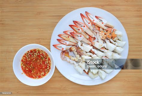 흰색 원형 접시에 찐 게 살과 매콤한 칠리 해산물 디핑 소스를 나무 판 배경에 담근다 먹을 준비가 되었습니다 맨 위 보기 갈고리 발톱에 대한 스톡 사진 및 기타 이미지