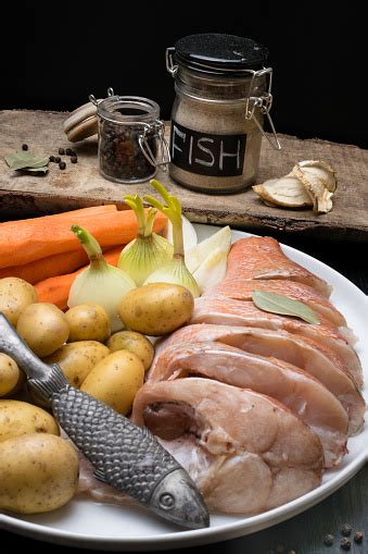 물고기 향료 당근 감자 고추 양파 베이 리프 어두운 배경에 셀러리와 요리 하지 않은 바다 농 건강 식품과 다이어트 개념입니다 생선 요리에 대 한 재료 감자 요리에 대한 스톡