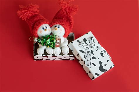 빨간 모자를 입은 눈사람 두 명이 소 반점과 비슷한 색칠이 있는 선물 상자에 앉아 있습니다 메리 크리스마스와 새해 컨셉 0명에 대한 스톡 사진 및 기타 이미지 Istock