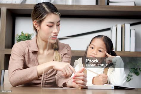 아시아 소녀는 집에서 엄마와 함께 기술 수업을 배우고 엄마는 투명 장치를 들고 있습니다 투명 태블릿으로 공부하는 생각하는 아이 영리하고 진보적인 아이가 It 코스를 방문하고