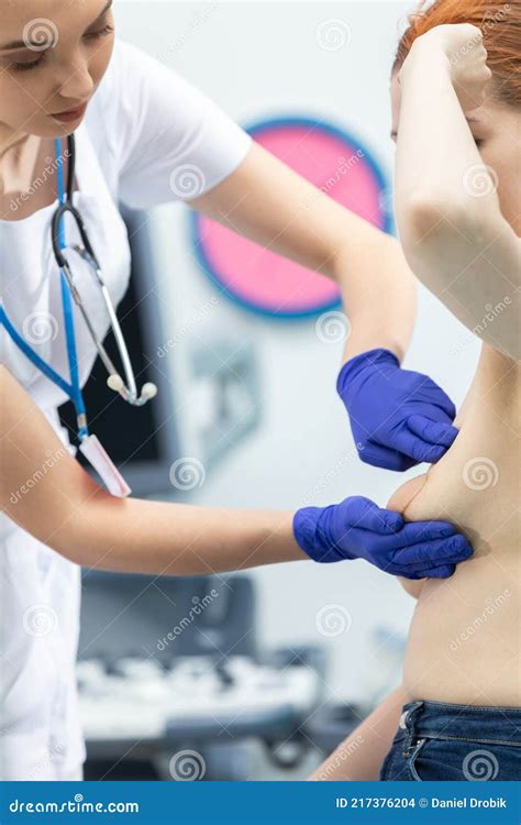 A Doctor Conducts A Breast Exam On A Young Patient Gently Applying