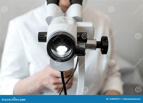 Young Female Professional Gynecologist In The Working Process Looks Into The Colposcope Stock