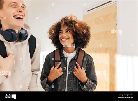 Two Laughing Teenagers In College Smiling Girl Looking At Her